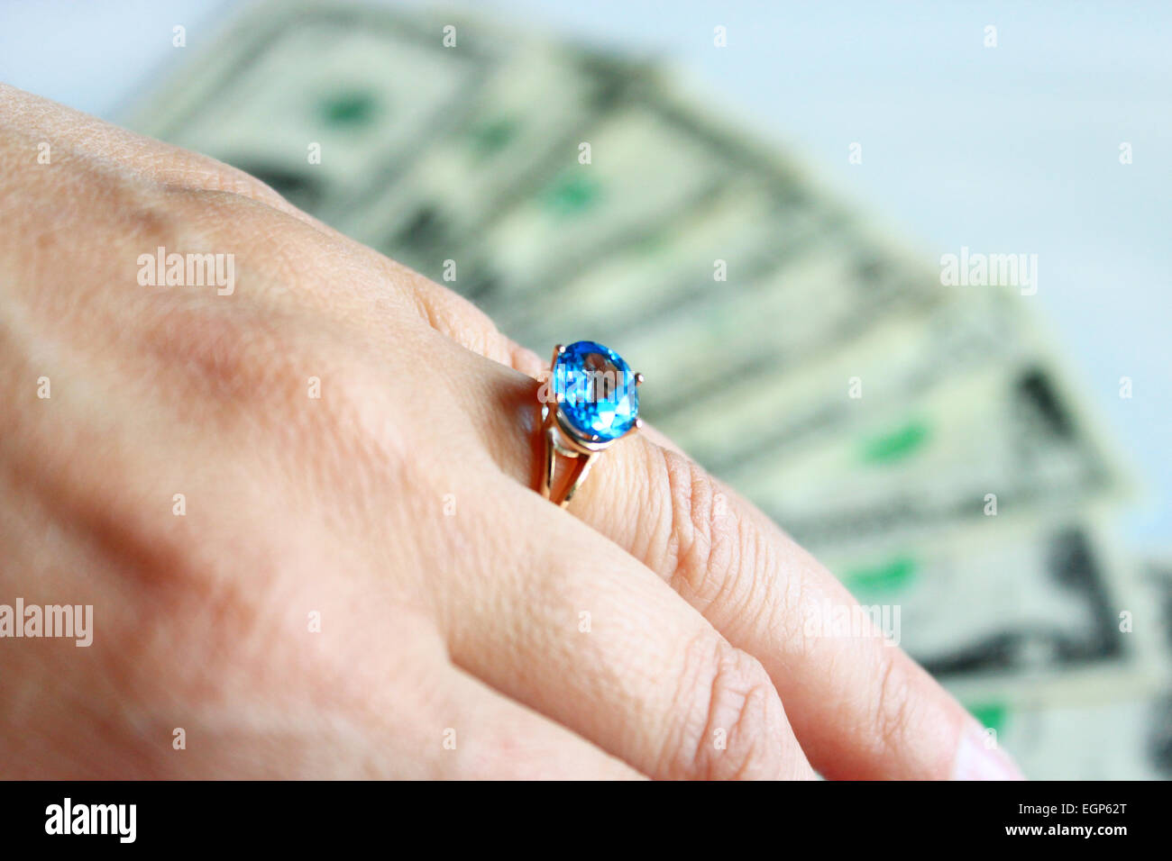Hand with topaz on the ring and dollars on the rare background Stock ...