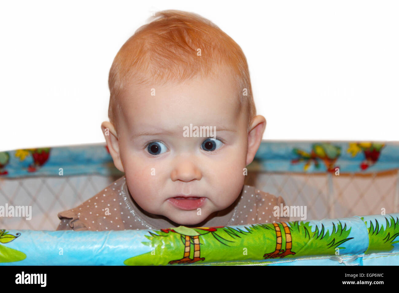 little baby standing in the playpen in perplexity isolated Stock Photo ...