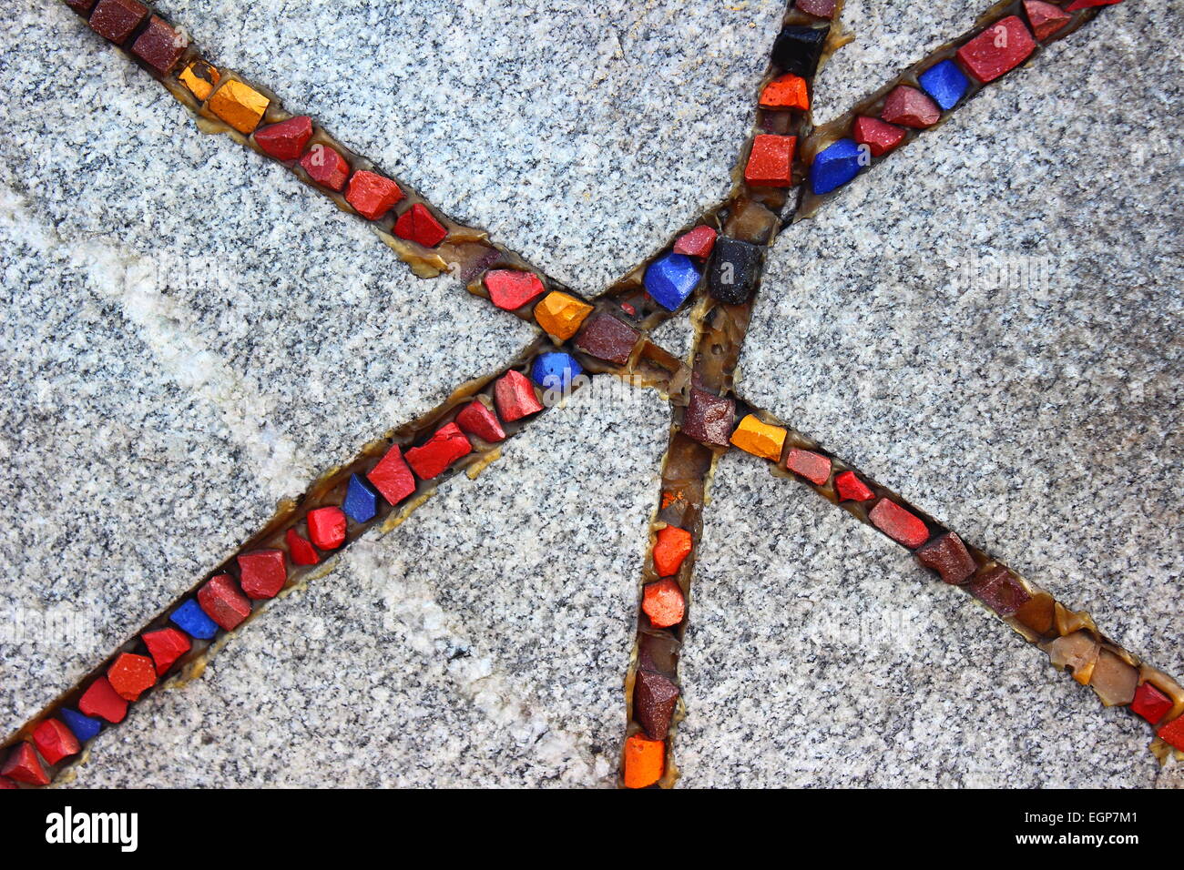 a large gray stone decorated with strips of colored stones Stock Photo ...