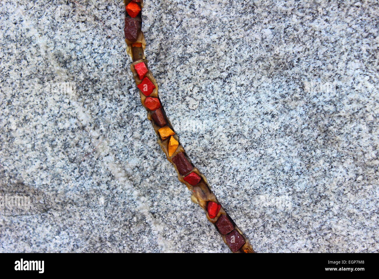 gray stone adorned with small colored stones of Stock Photo - Alamy