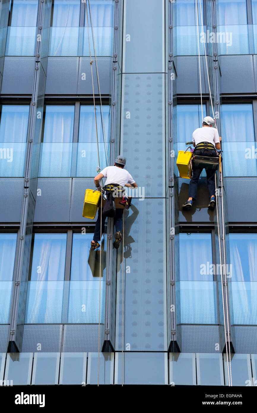 Two climbers wash windows and glass facade of the skyscraper Stock ...