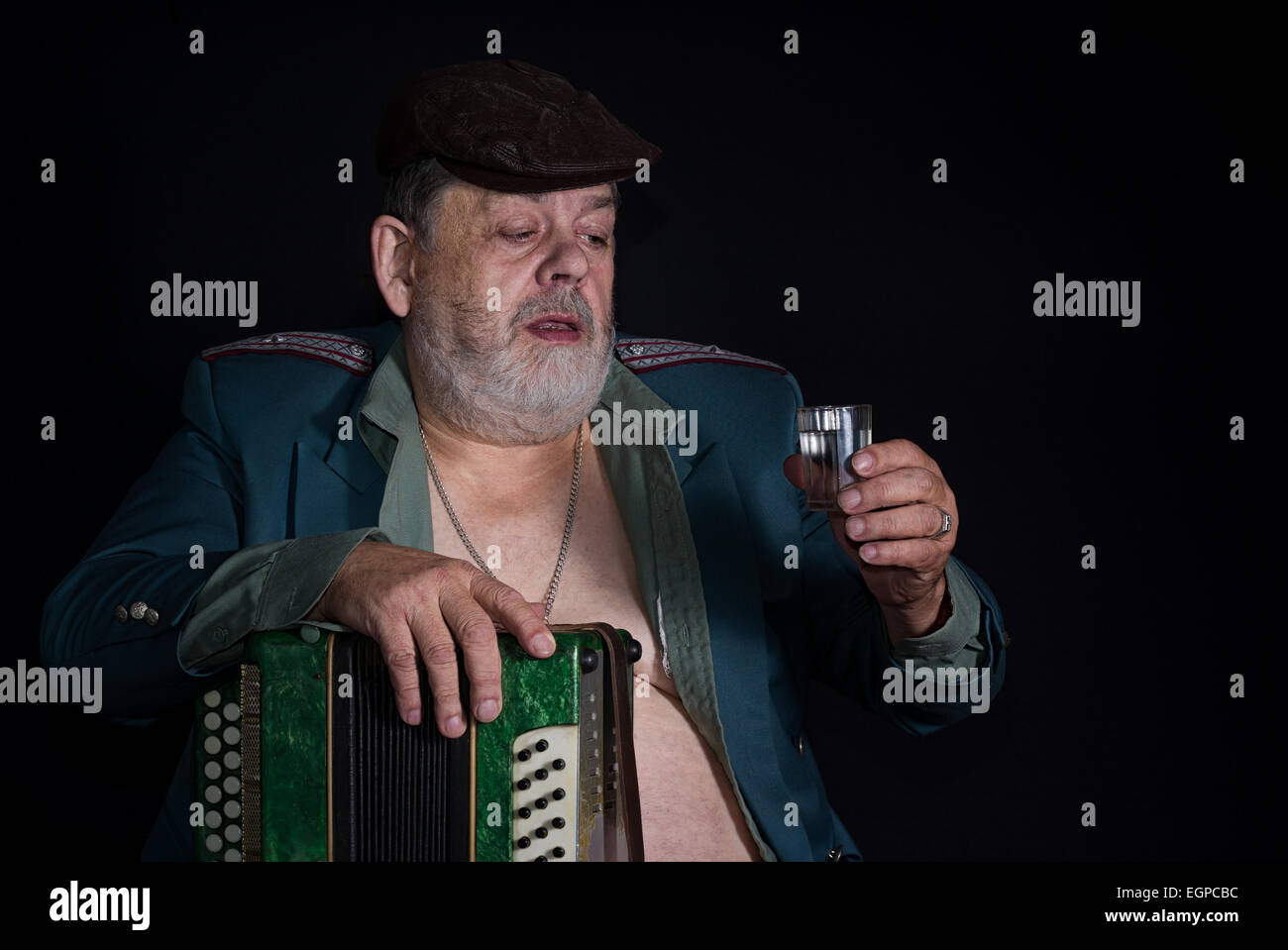 Portrait of an old retired military man who is ready to drink glass of ...