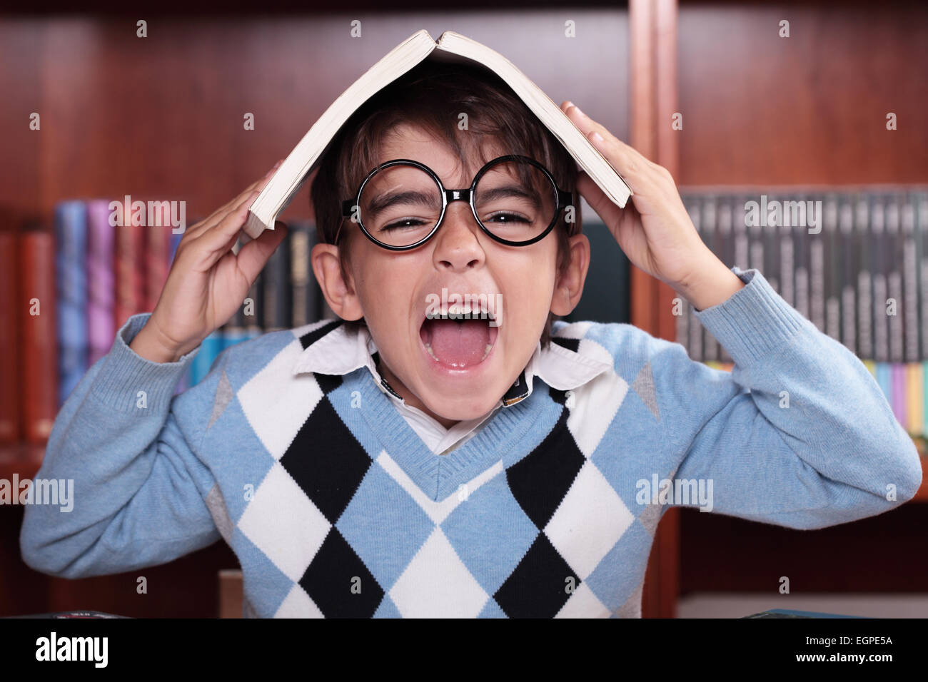 Child studying and screaming in the library Stock Photo - Alamy