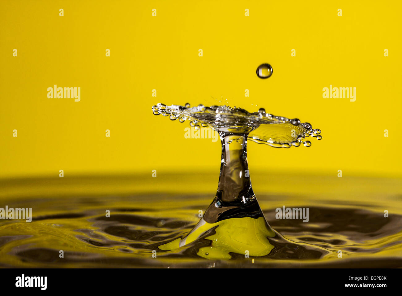 Water drop collisions with a yellow background Stock Photo - Alamy