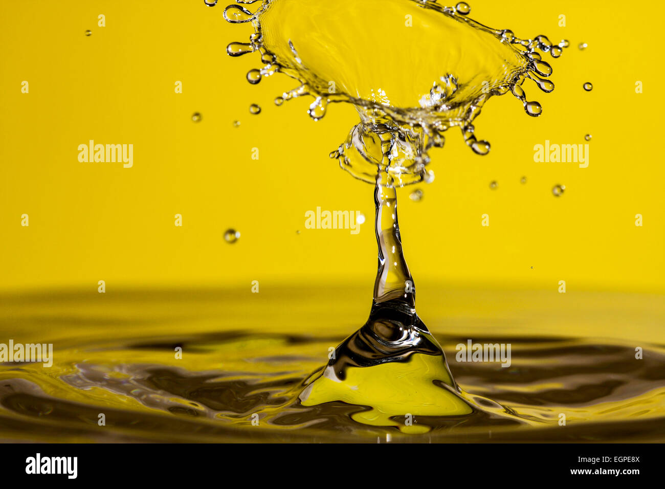 Water drop collisions with a yellow background Stock Photo - Alamy