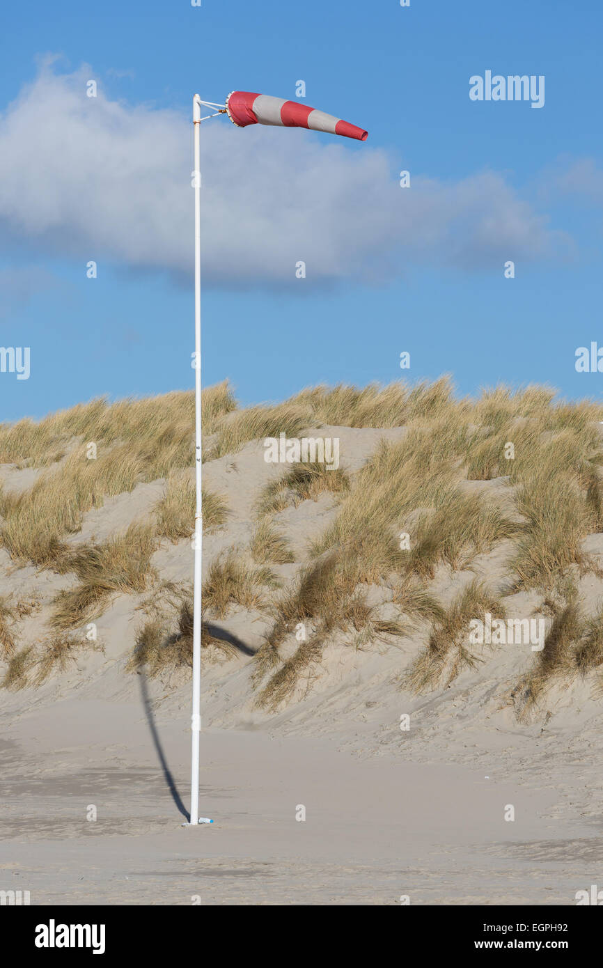 A windsock blows in strong winds with sand dunes behind Stock Photo - Alamy