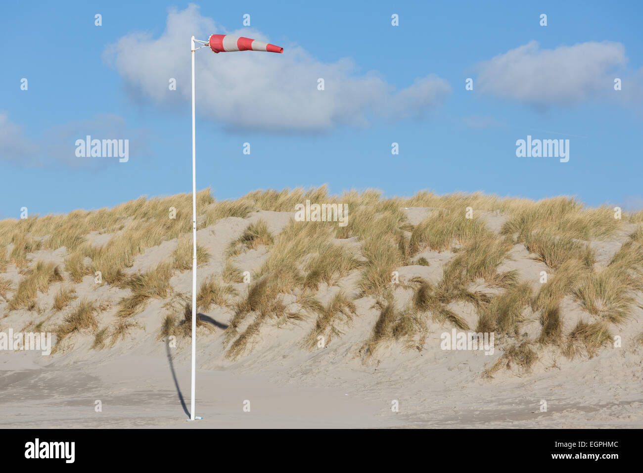 A windsock blows in strong winds with sand dunes behind Stock Photo - Alamy