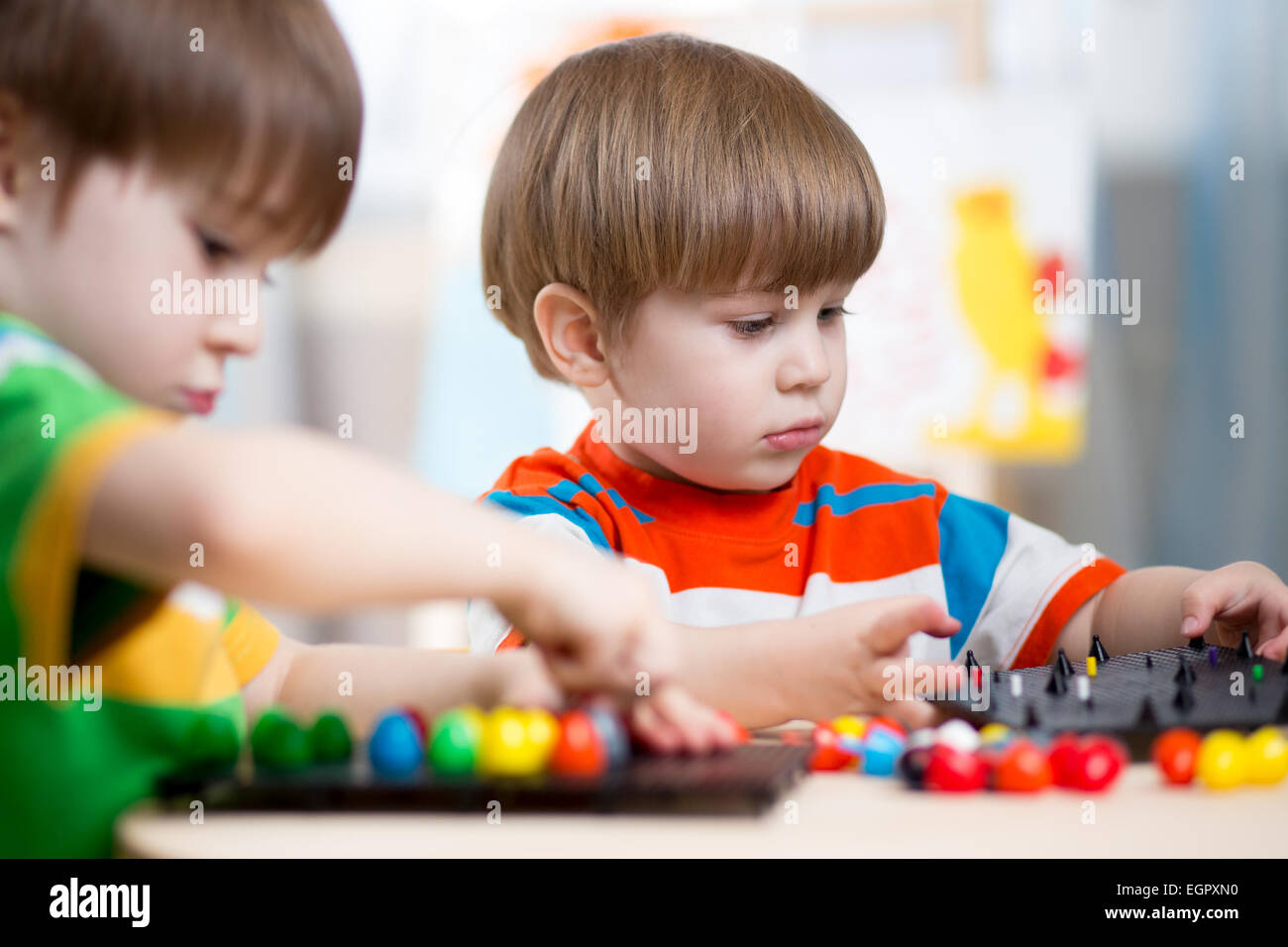two kids brothers play together at table Stock Photo - Alamy