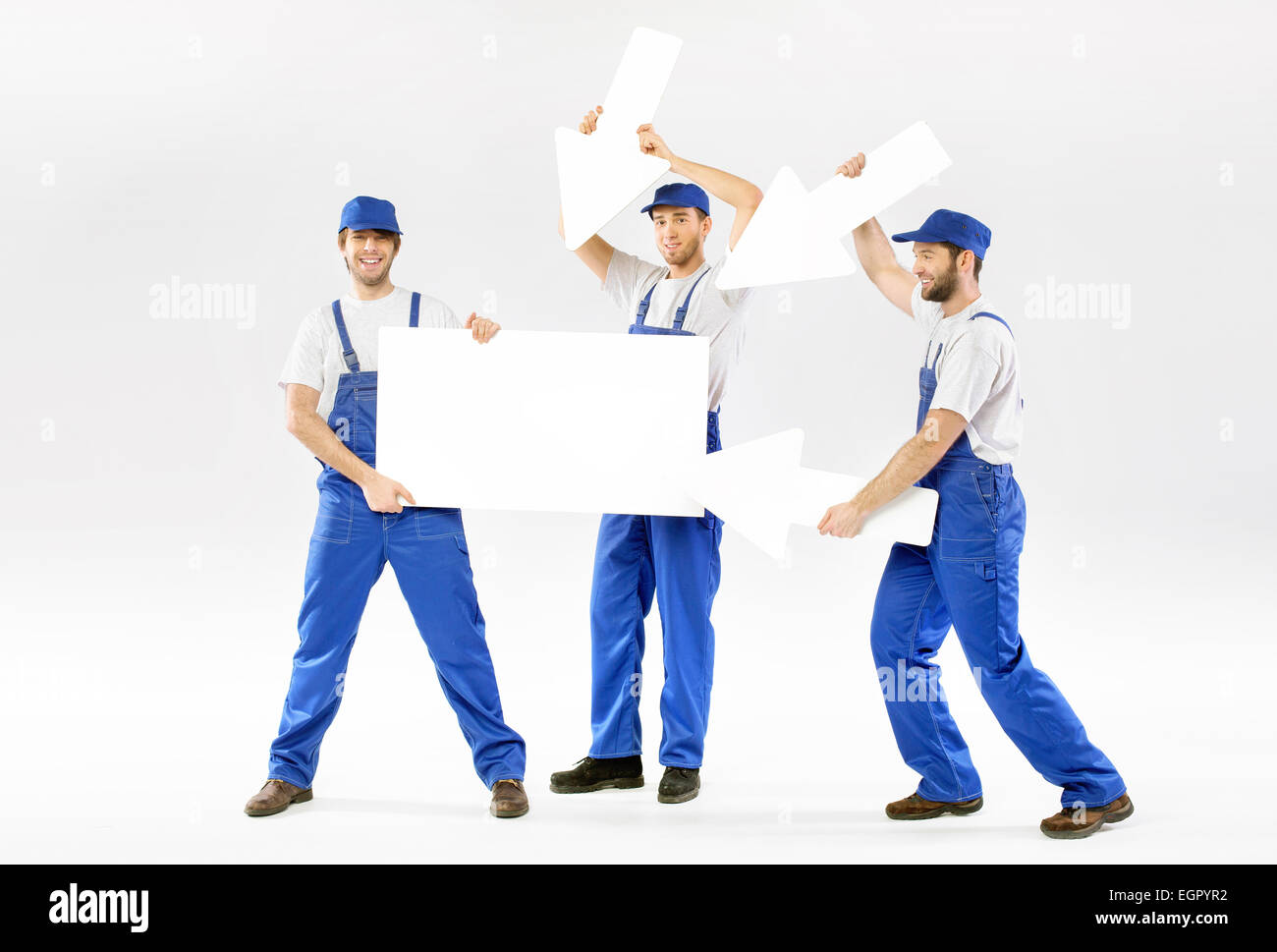 Three cheerful workers with empty board Stock Photo - Alamy
