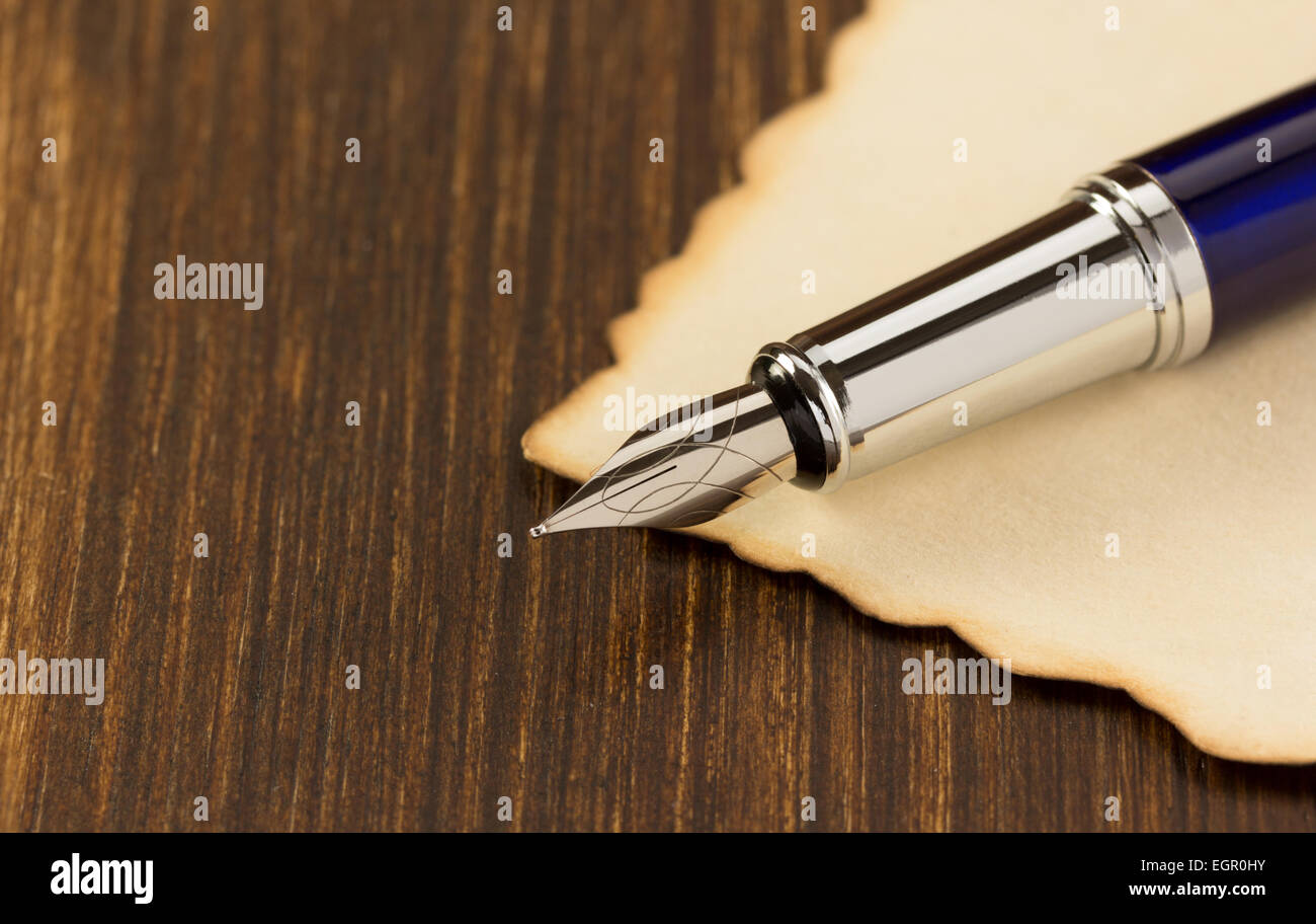ink pen and paper parchment on wooden background Stock Photo - Alamy