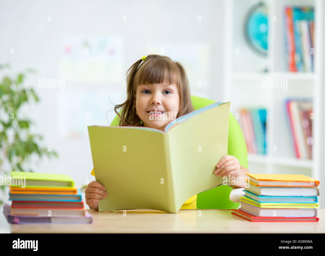 kid girl with opened book at home Stock Photo - Alamy