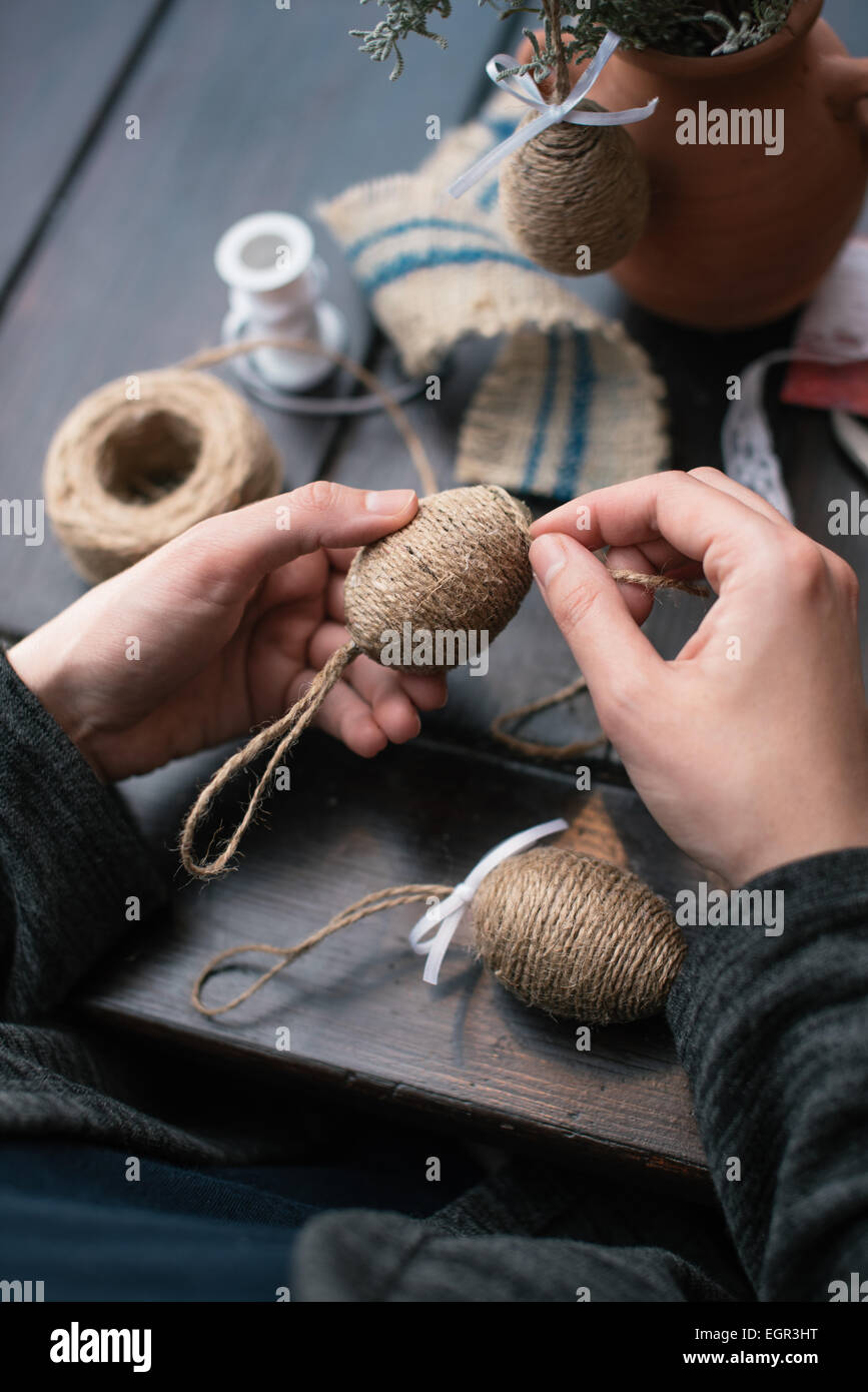 Woman decorating easter eggs with rope Stock Photo - Alamy