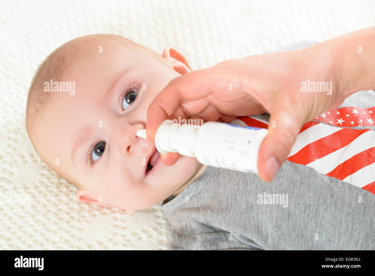 Woman using nasal spray for baby Stock Photo - Alamy