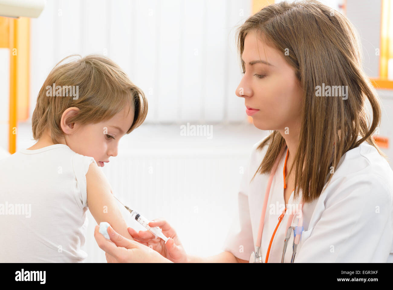 Cute boy being injected at clinic Stock Photo - Alamy