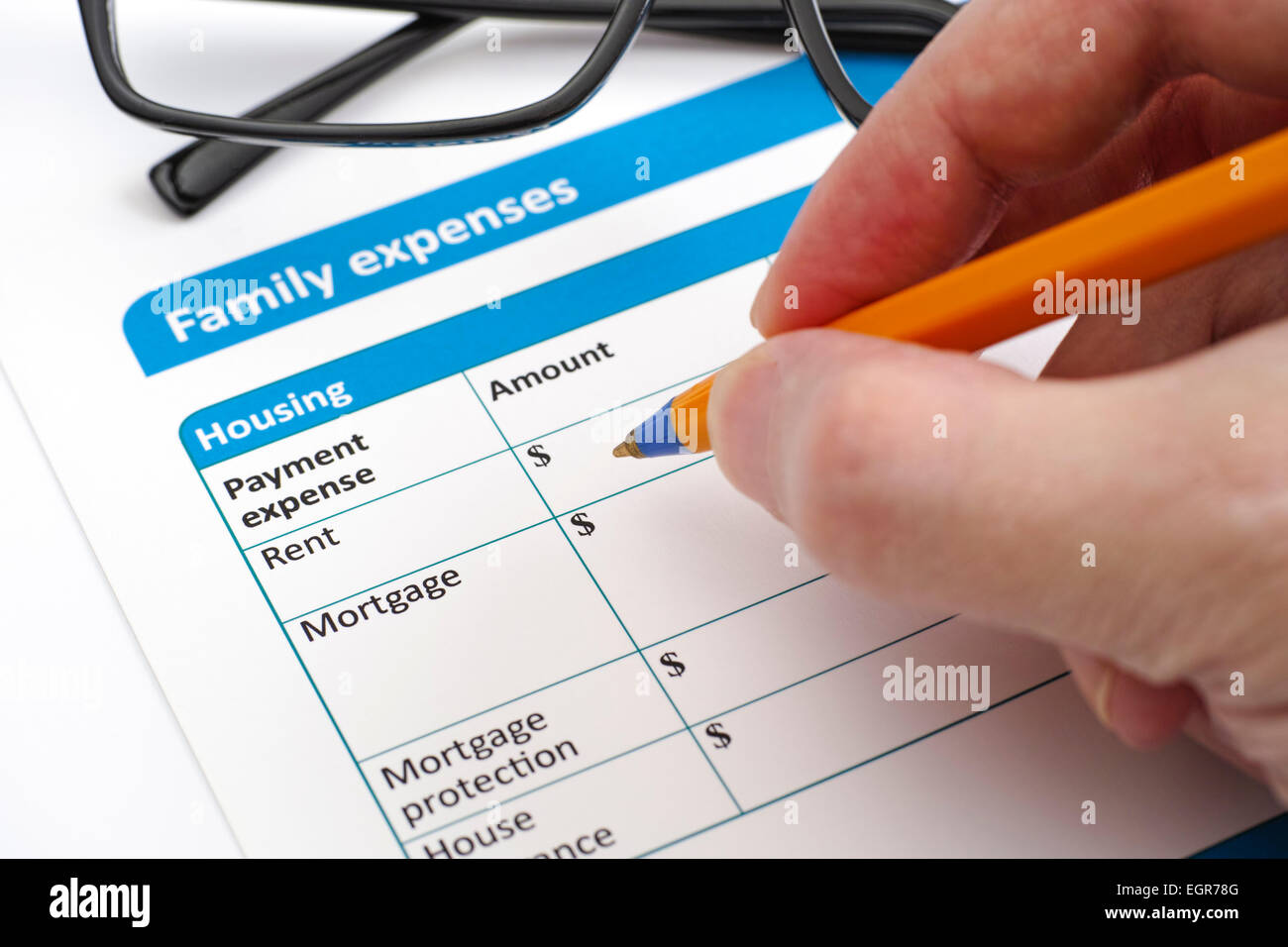 Family expenses application form, glasses and human hand with ballpoint ...