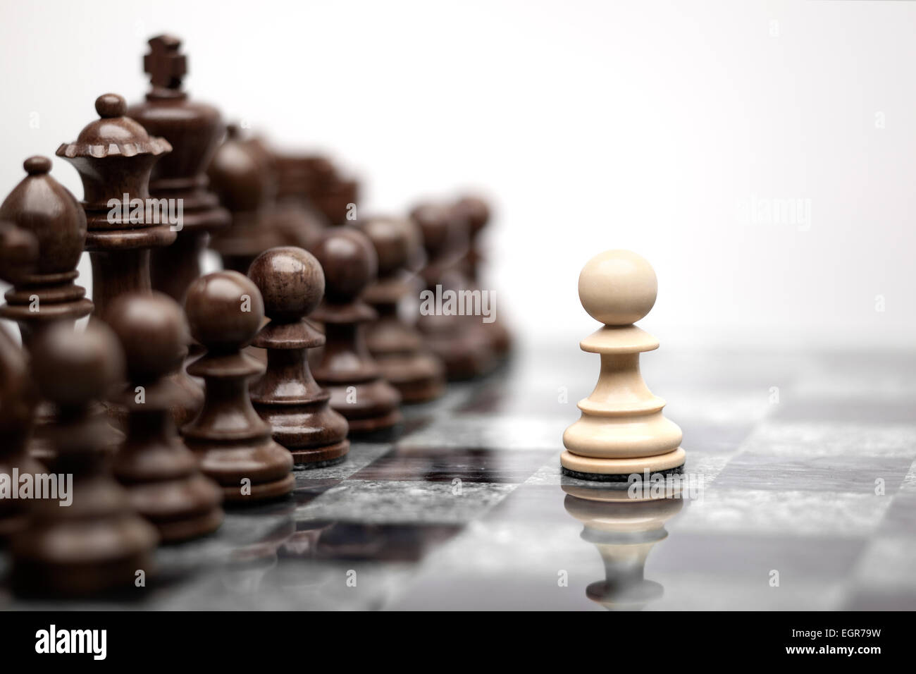 One pawn staying against full set of chess pieces Stock Photo - Alamy