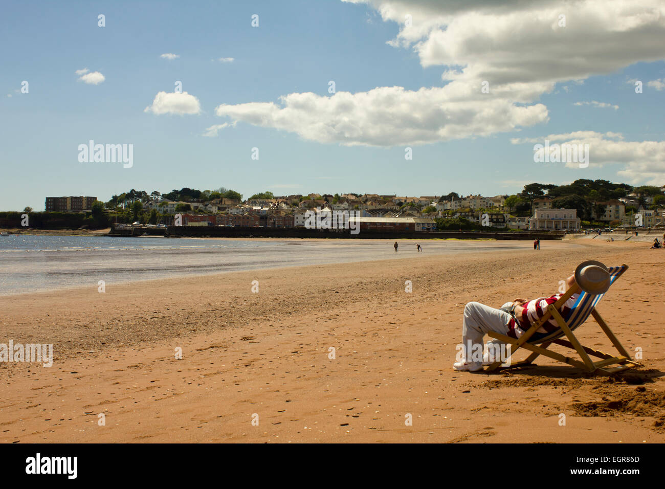 Man in a deckchair on the beach, relaxing on a sunny day at Paignton ...