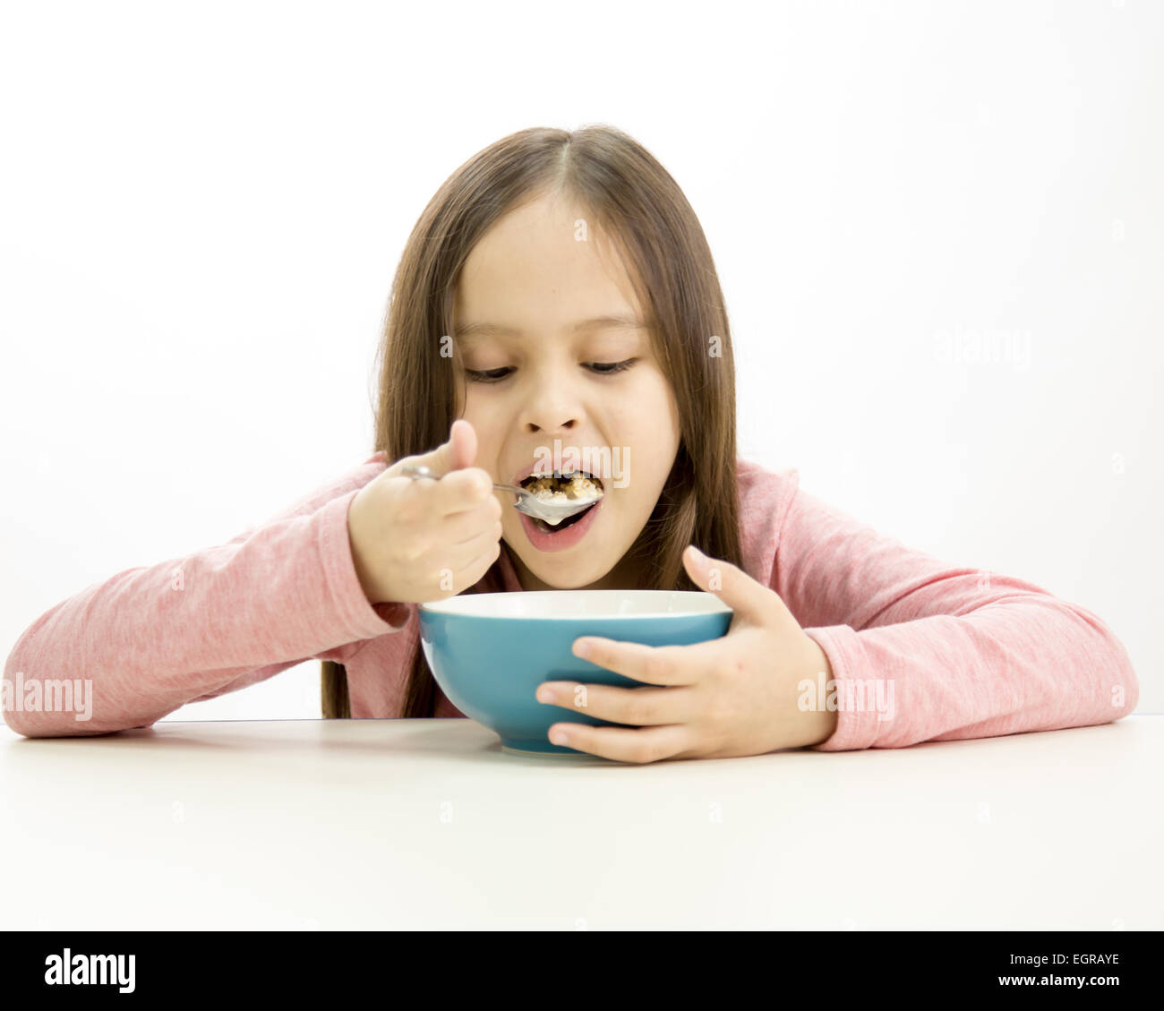 Young girl eating cereal from bowl for her breakfast Stock Photo - Alamy