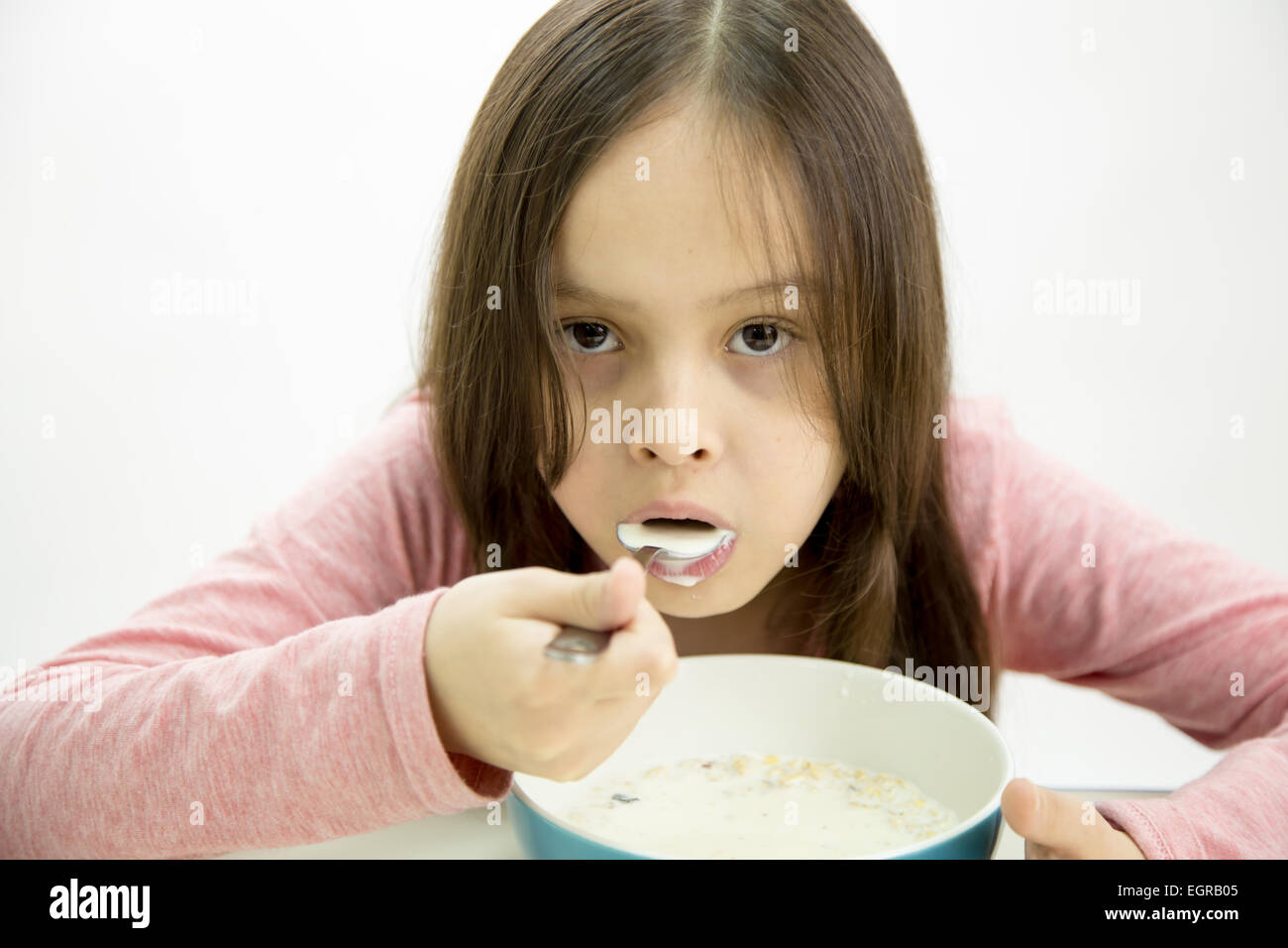 Young girl eating cereal from bowl for her breakfast Stock Photo - Alamy