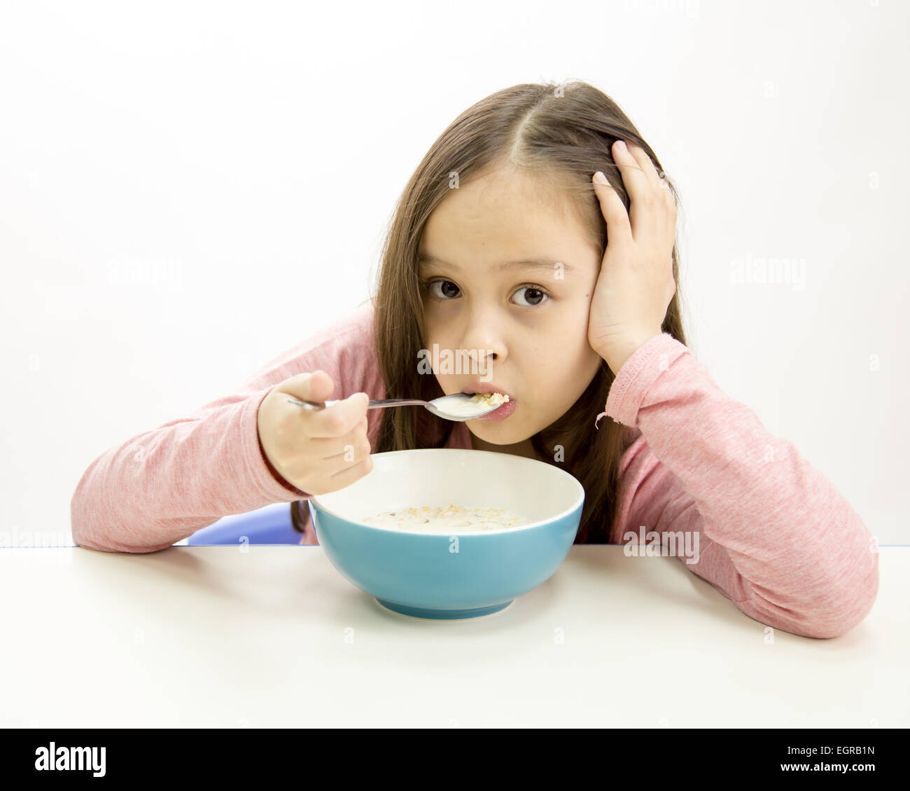 Young girl eating cereal from bowl for her breakfast Stock Photo - Alamy