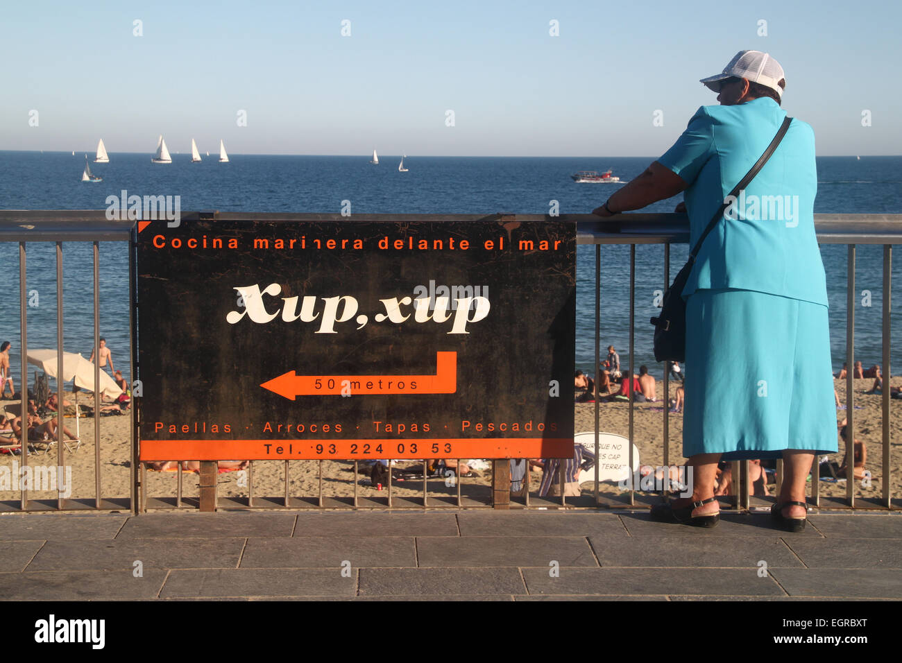 Woman next to restaurant sign on seafront Passeig Maritim, Barceloneta ...