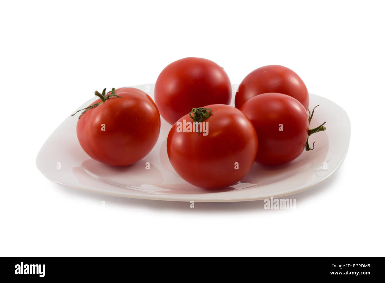 five ripe tomatoes in a bowl on a white background Stock Photo - Alamy