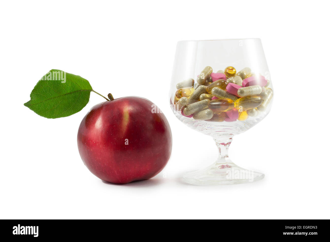 tablets in a glass and red apple close up Stock Photo - Alamy