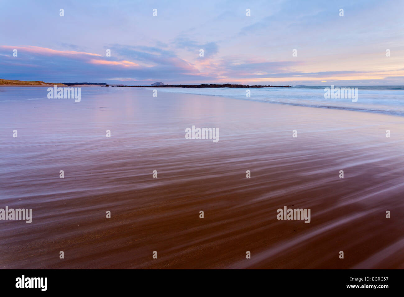Streaky patterns created by retreating waves on the sandy shores of ...
