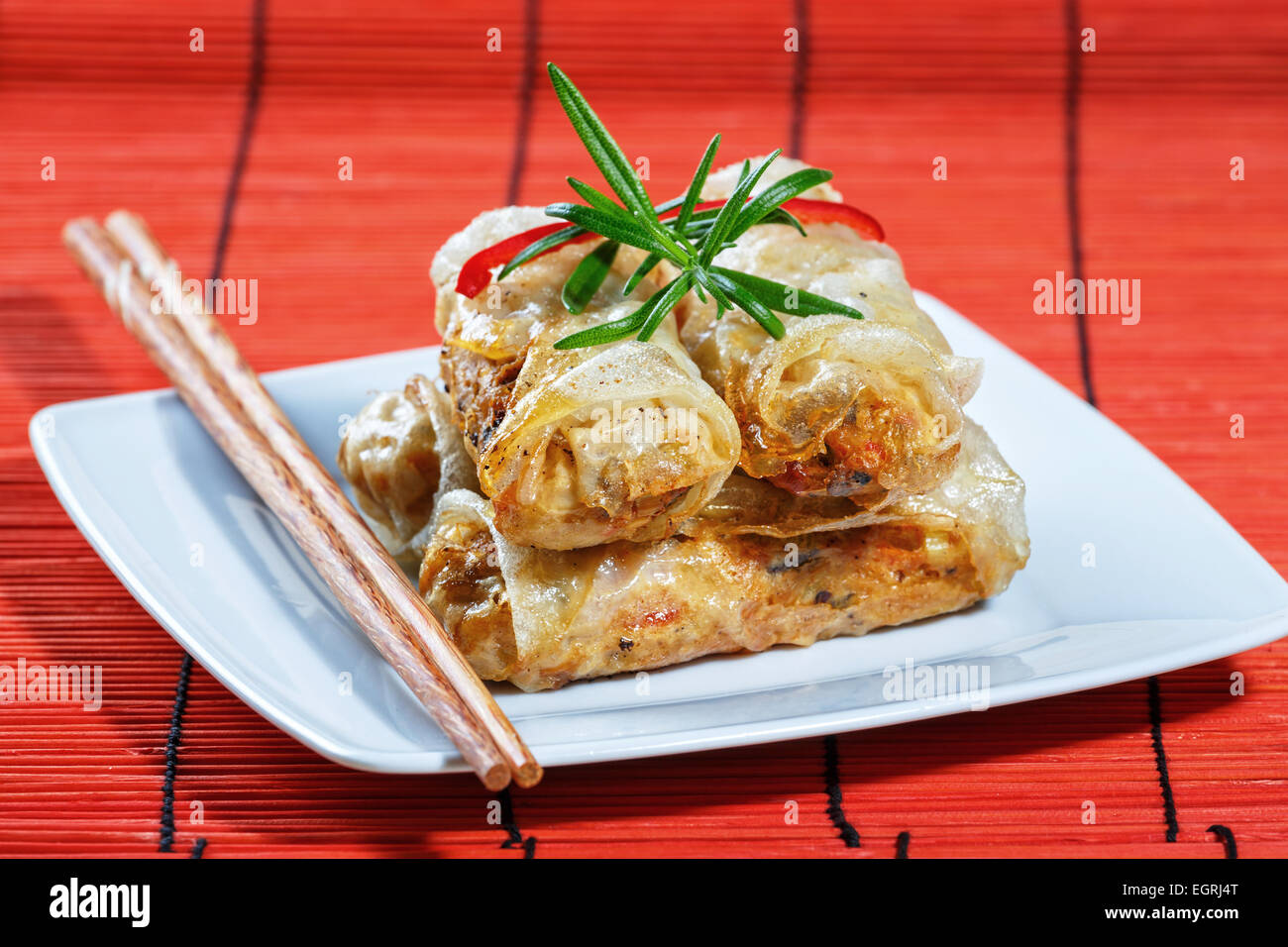 fried spring rolls on red bamboo mat Stock Photo - Alamy