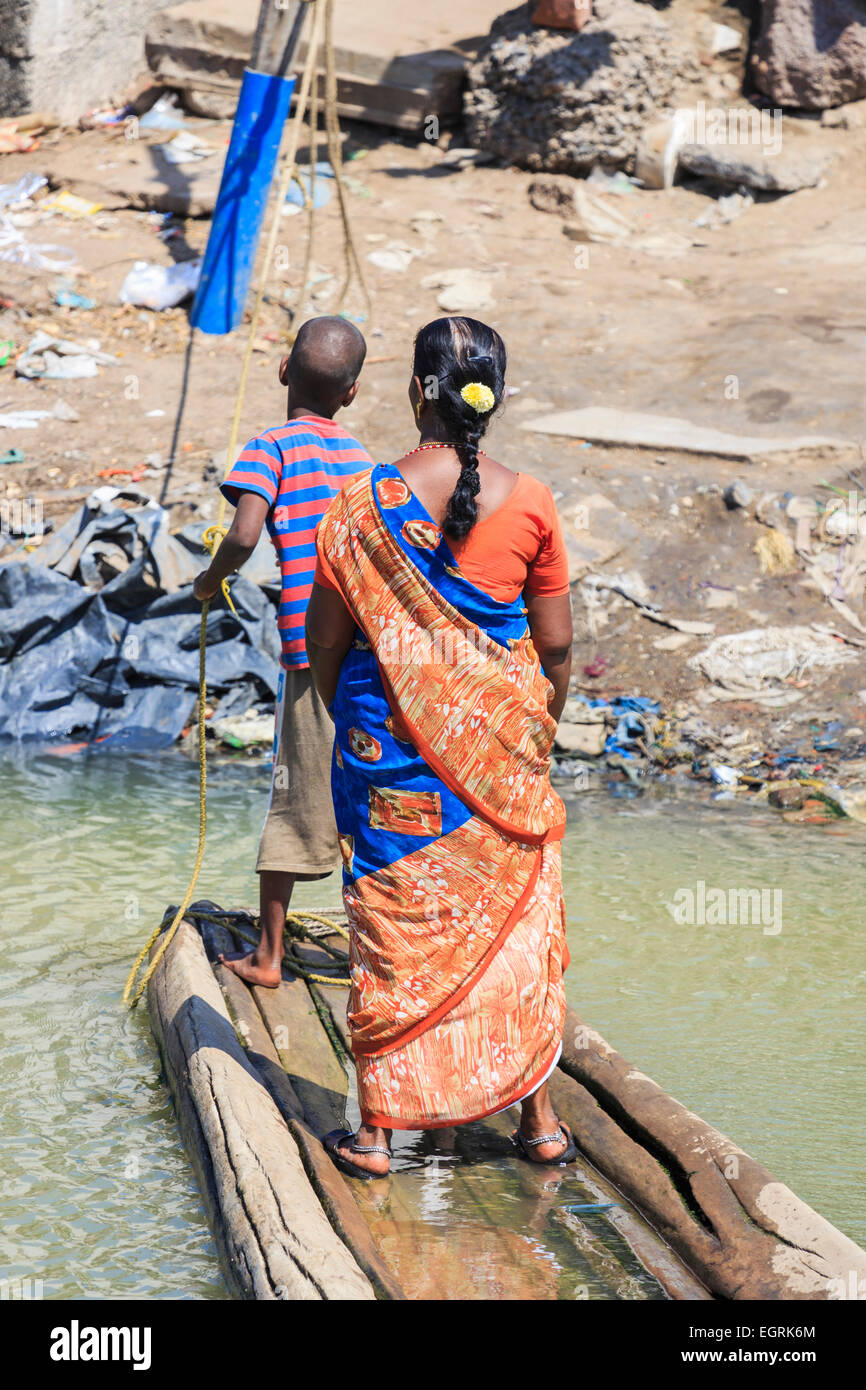 Local woman in colourful sari on a makeshift wooden ferry in slums on ...