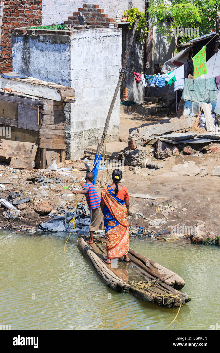 Local woman in colourful sari on a makeshift wooden ferry in slums on ...