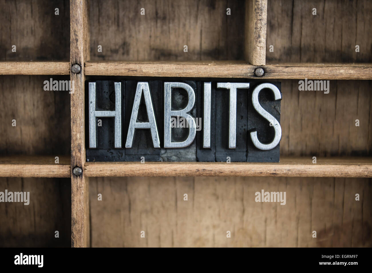 The word "HABITS" written in vintage metal letterpress type in a wooden ...