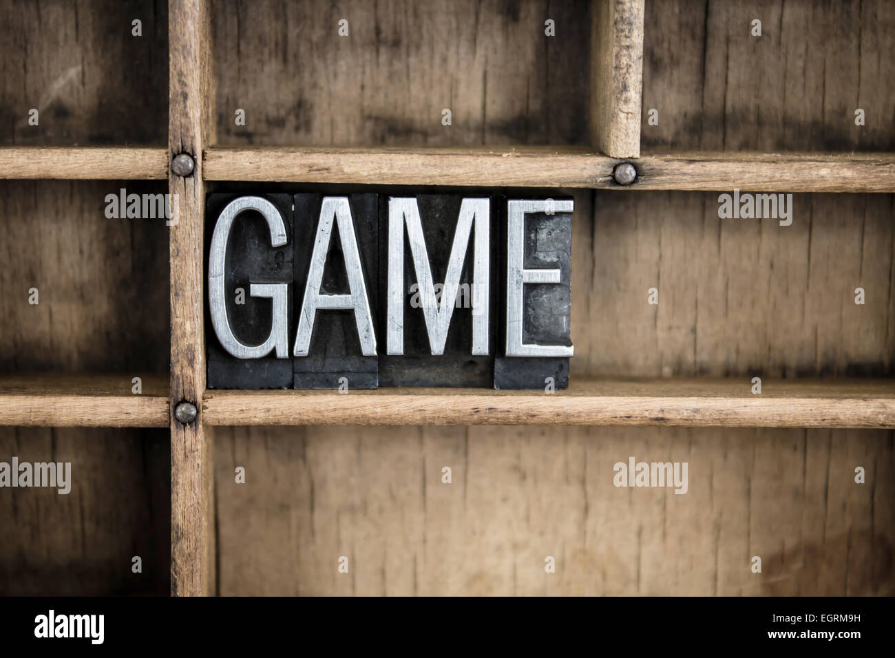 The word "GAME" written in vintage metal letterpress type in a wooden ...