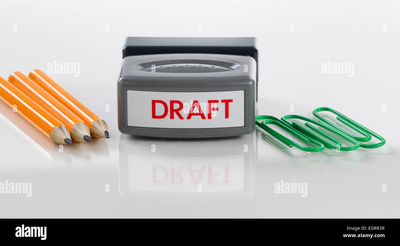 Draft stamp, paper clips and pencils on glass with white background and ...