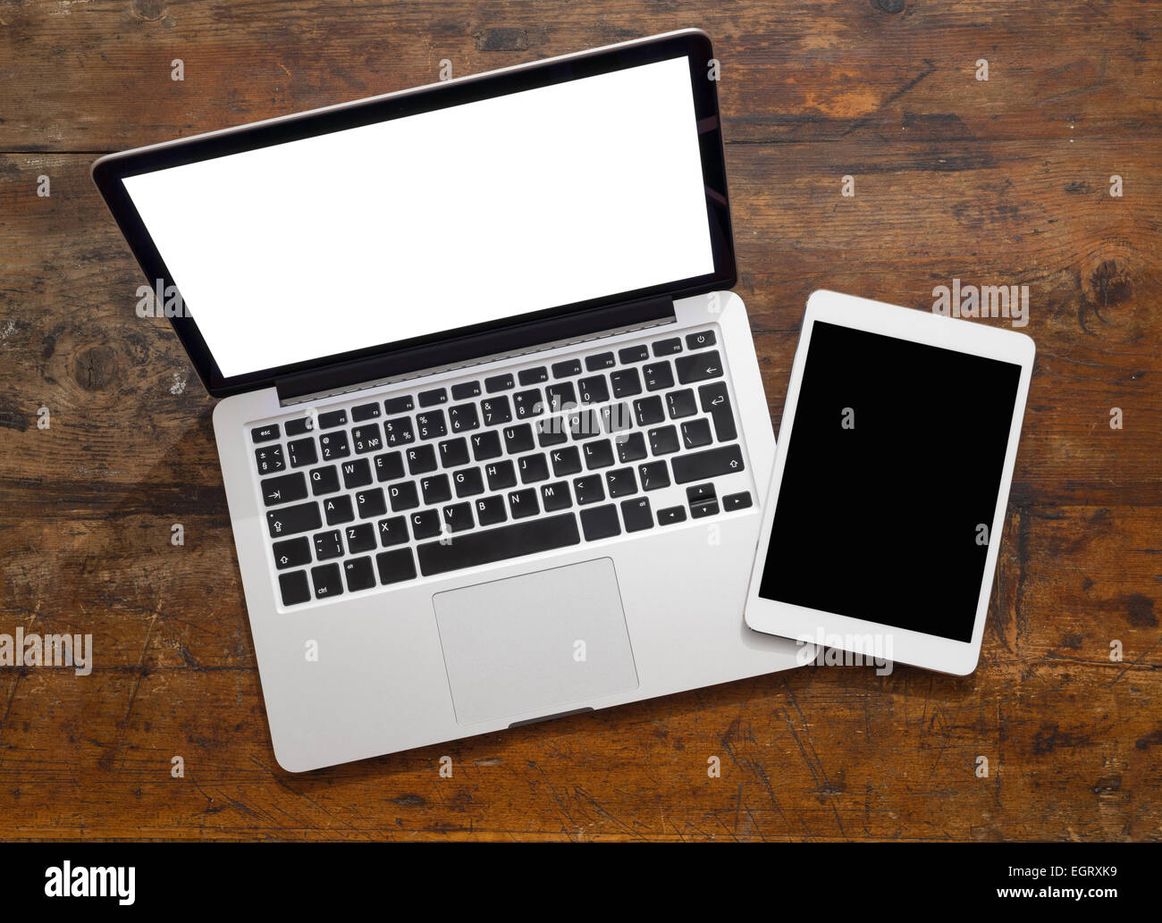 Open laptop with digital tablet, with isolated screen on old wooden ...