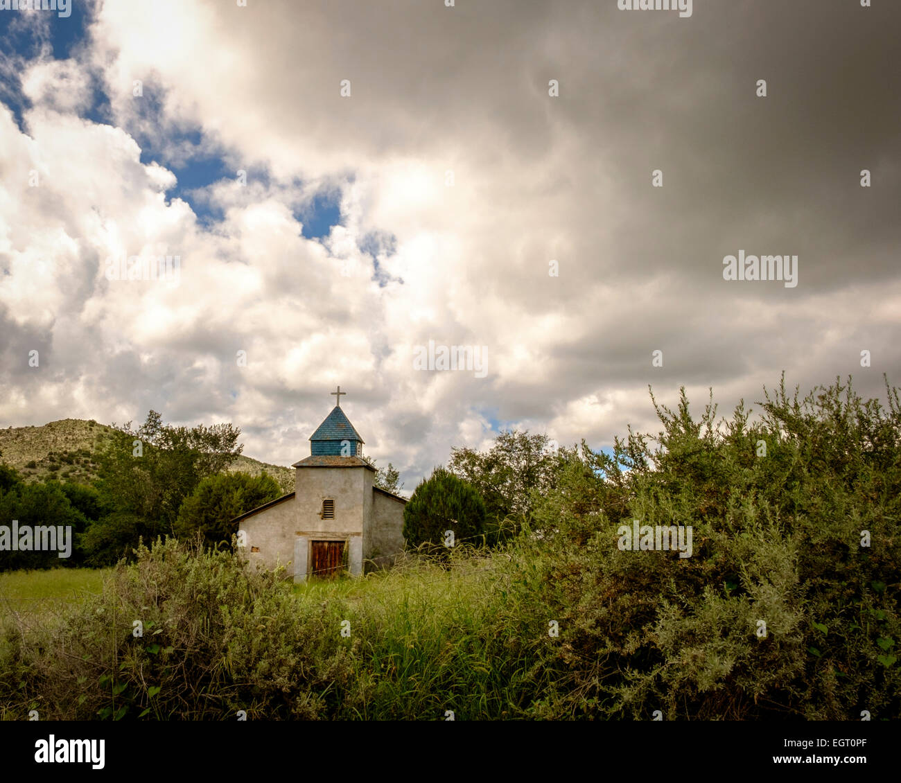 Old church in overgrown landscape with cloudy skies, in southeast New ...