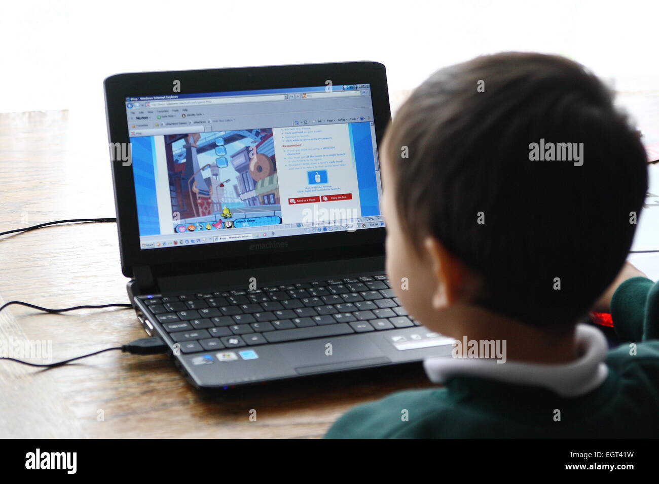 A young child using a laptop with laptop in focus Stock Photo - Alamy