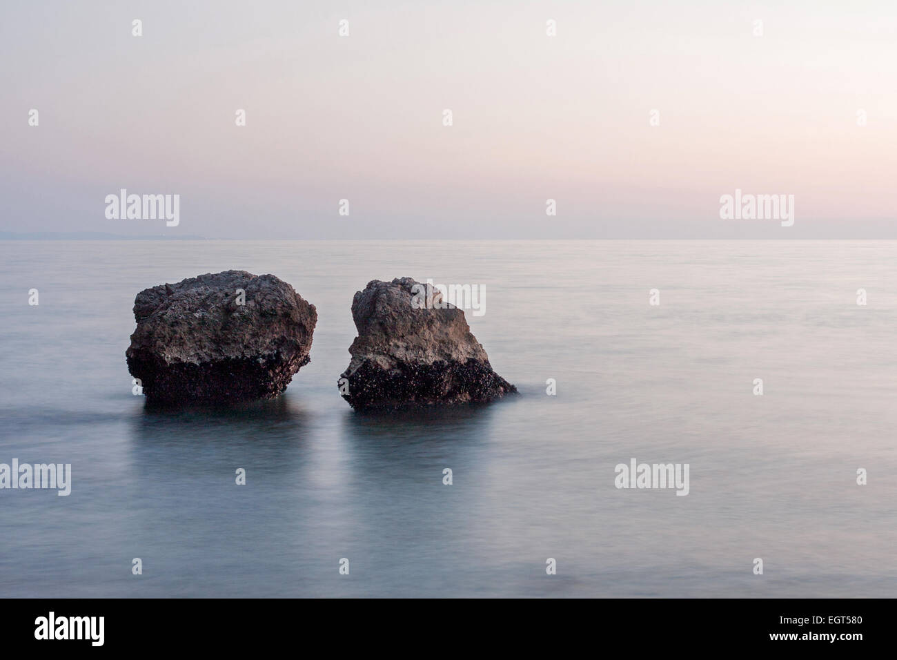 Rock on the sea in a calm sunset Stock Photo - Alamy