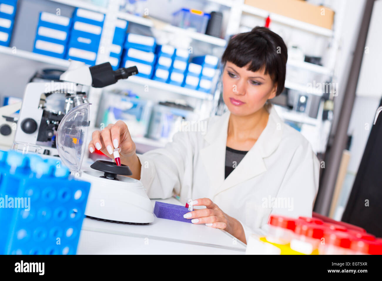 woman in a laboratory with microtube test tube in hand and PCR ...