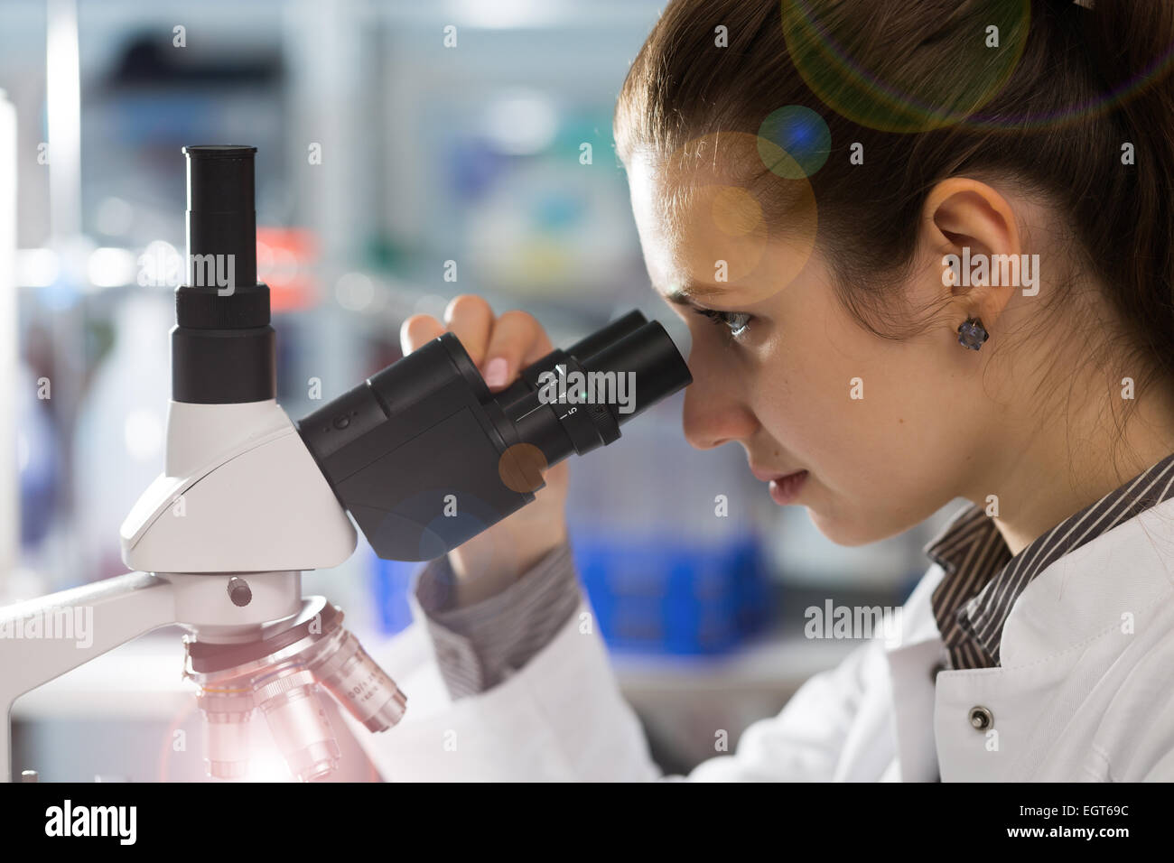 Scientist young woman using a microscope in a science laboratory Stock ...