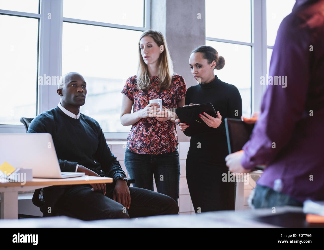 Business people having informal meeting in office. Diverse team of ...