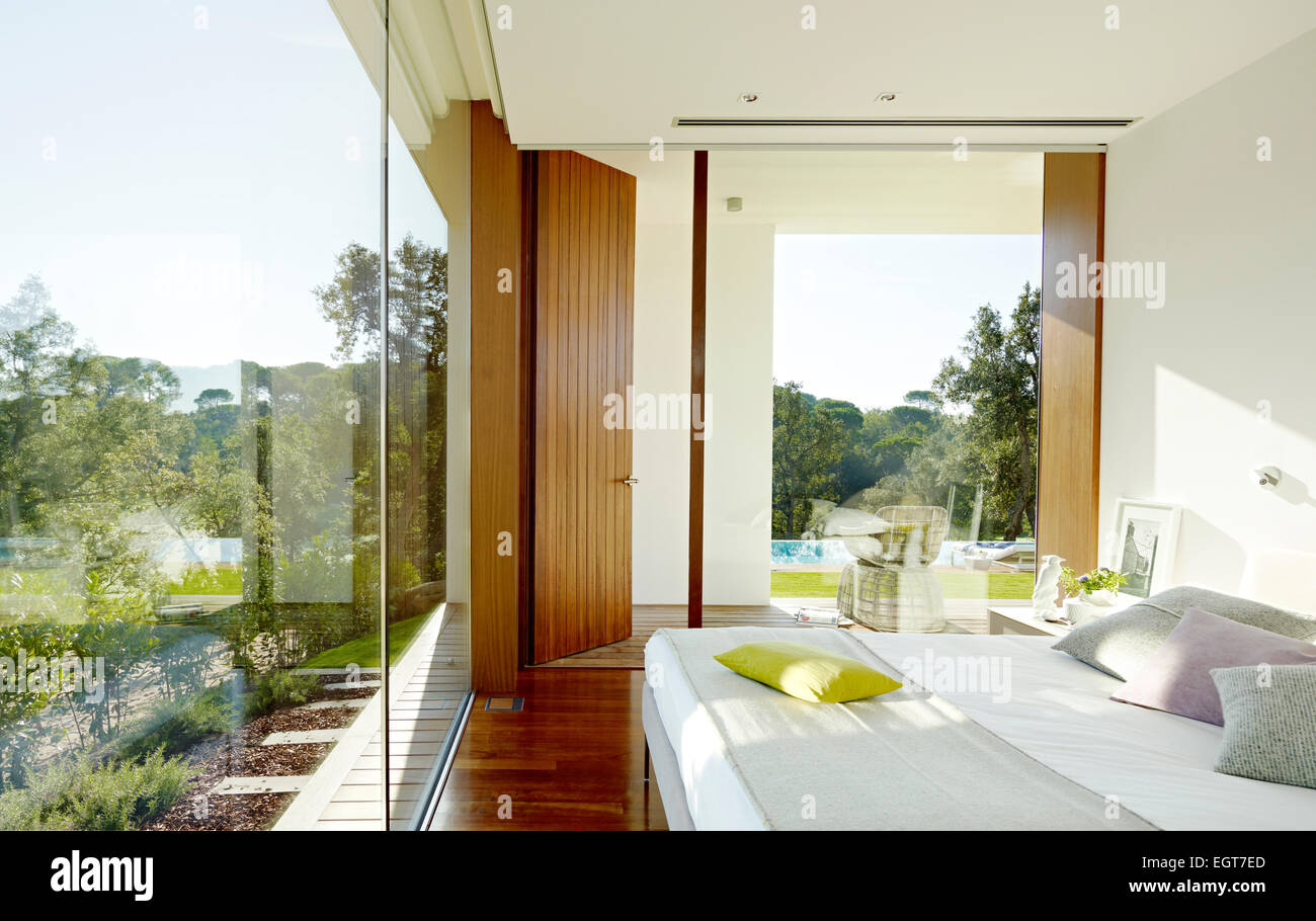 Double bed in room with full length windows, modern residential home in ...