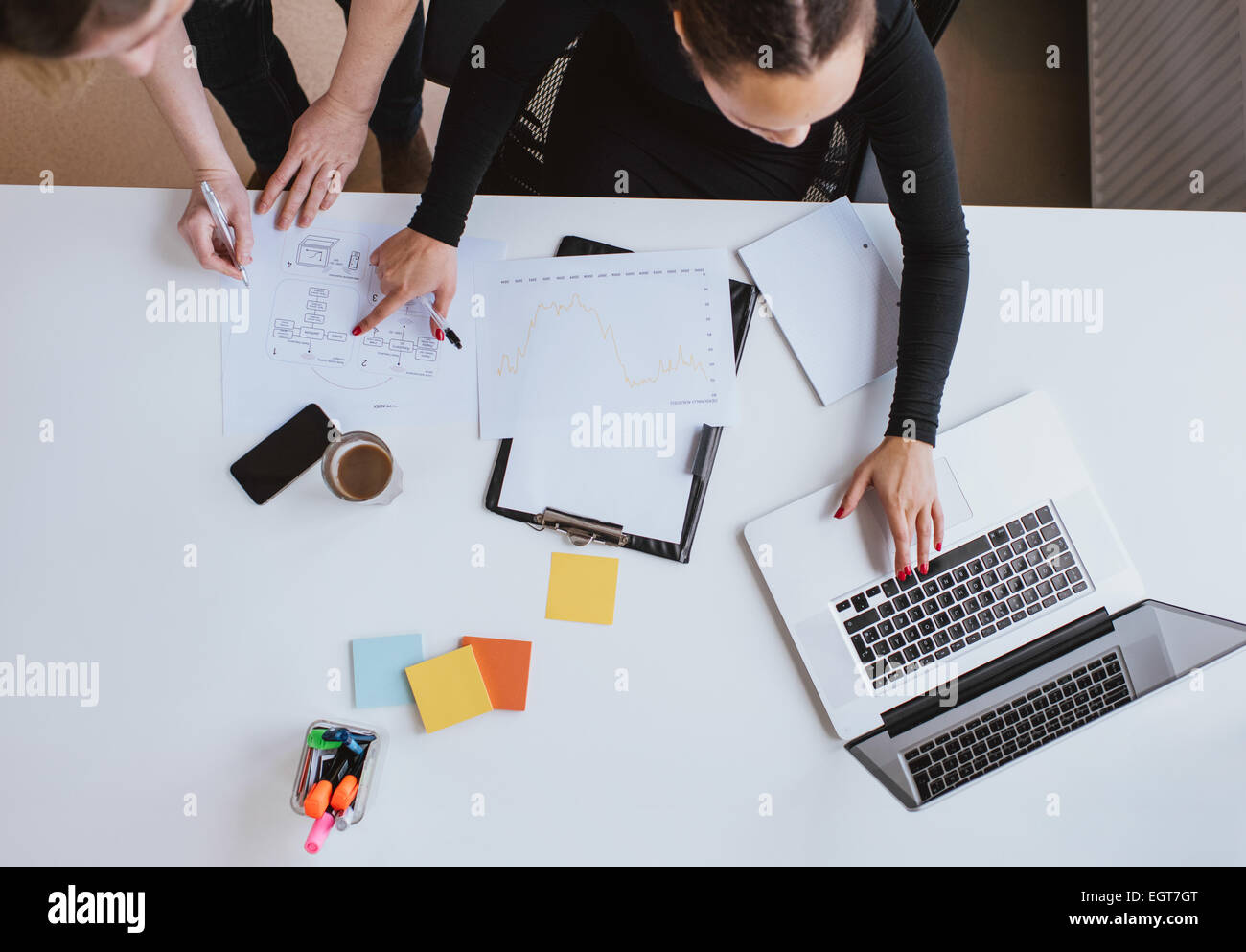 Business team working on a new plan with laptop. Top view of two young ...