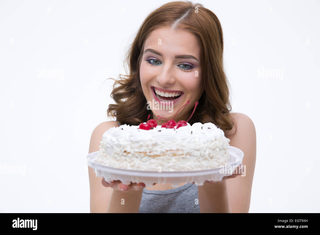 Laughing woman looking at the cake over gray background Stock Photo - Alamy