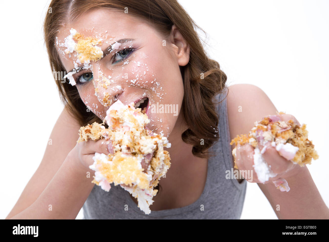 Young cute woman eating cake over white background Stock Photo - Alamy