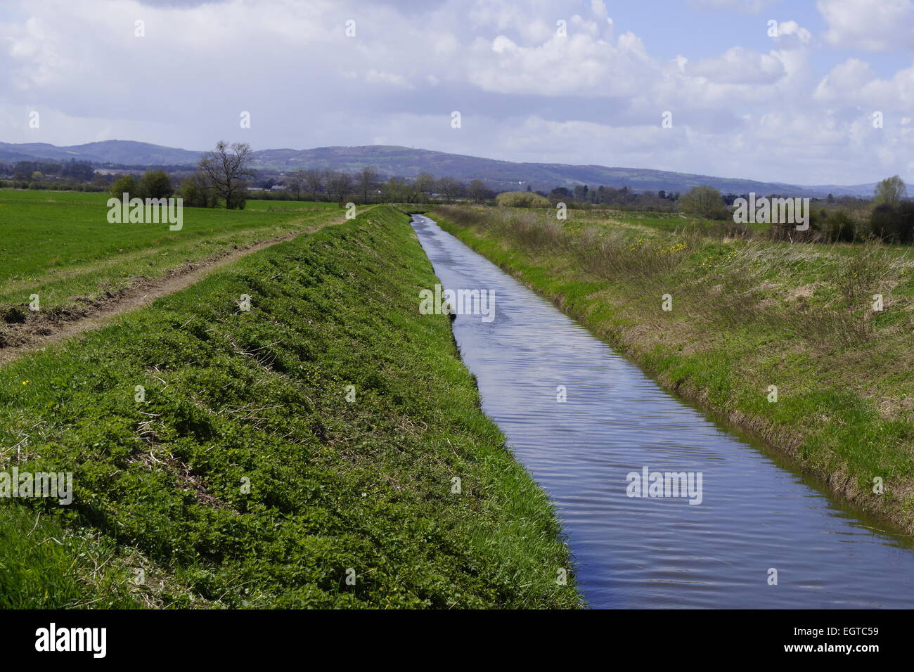 Farmland drainage ditch Nr.Chester, filled with water with Welsh hills ...