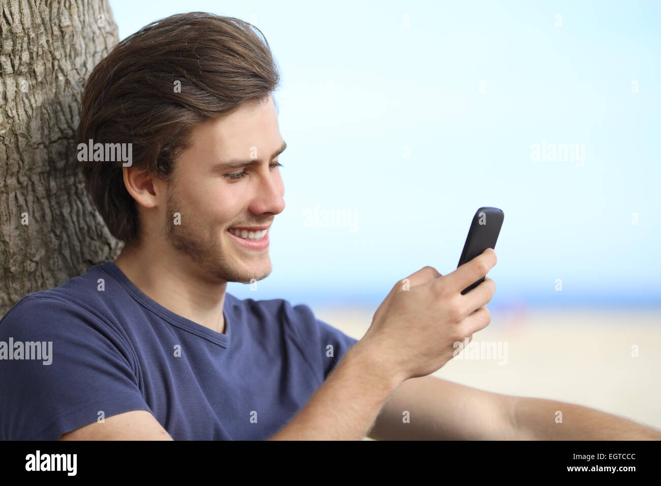 Young teenager boy sharing social media in a smart phone with the sky ...
