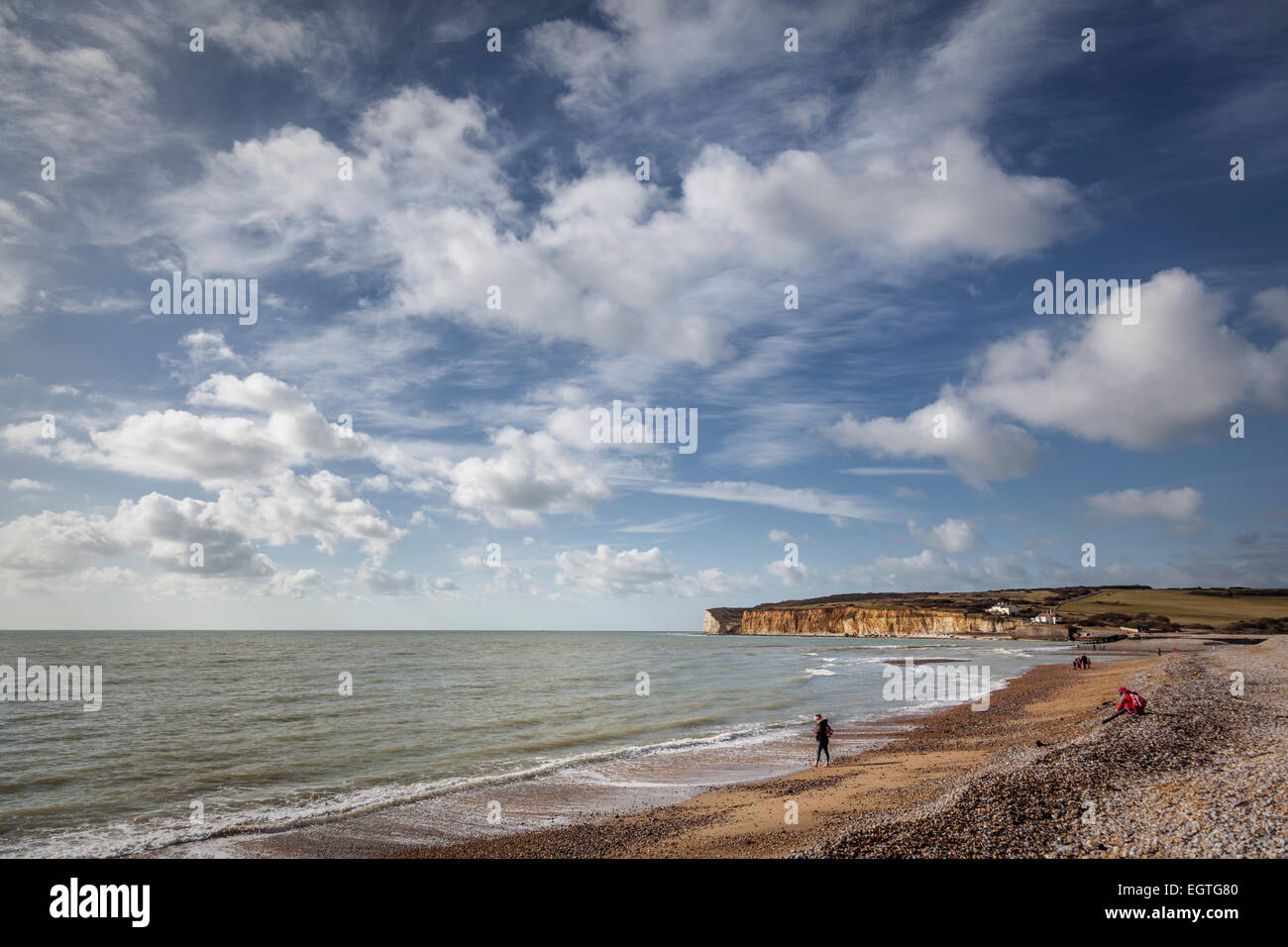 The shingle beach at Cuckmere Haven at high tide with the estuary of ...