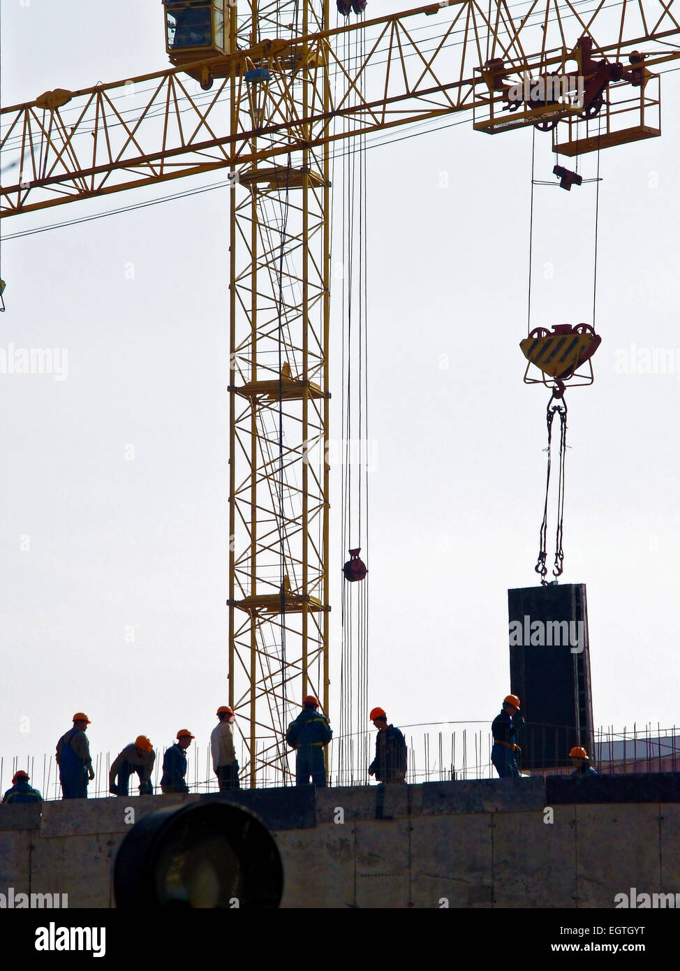 Constructions workers lifting concrete block Stock Photo - Alamy