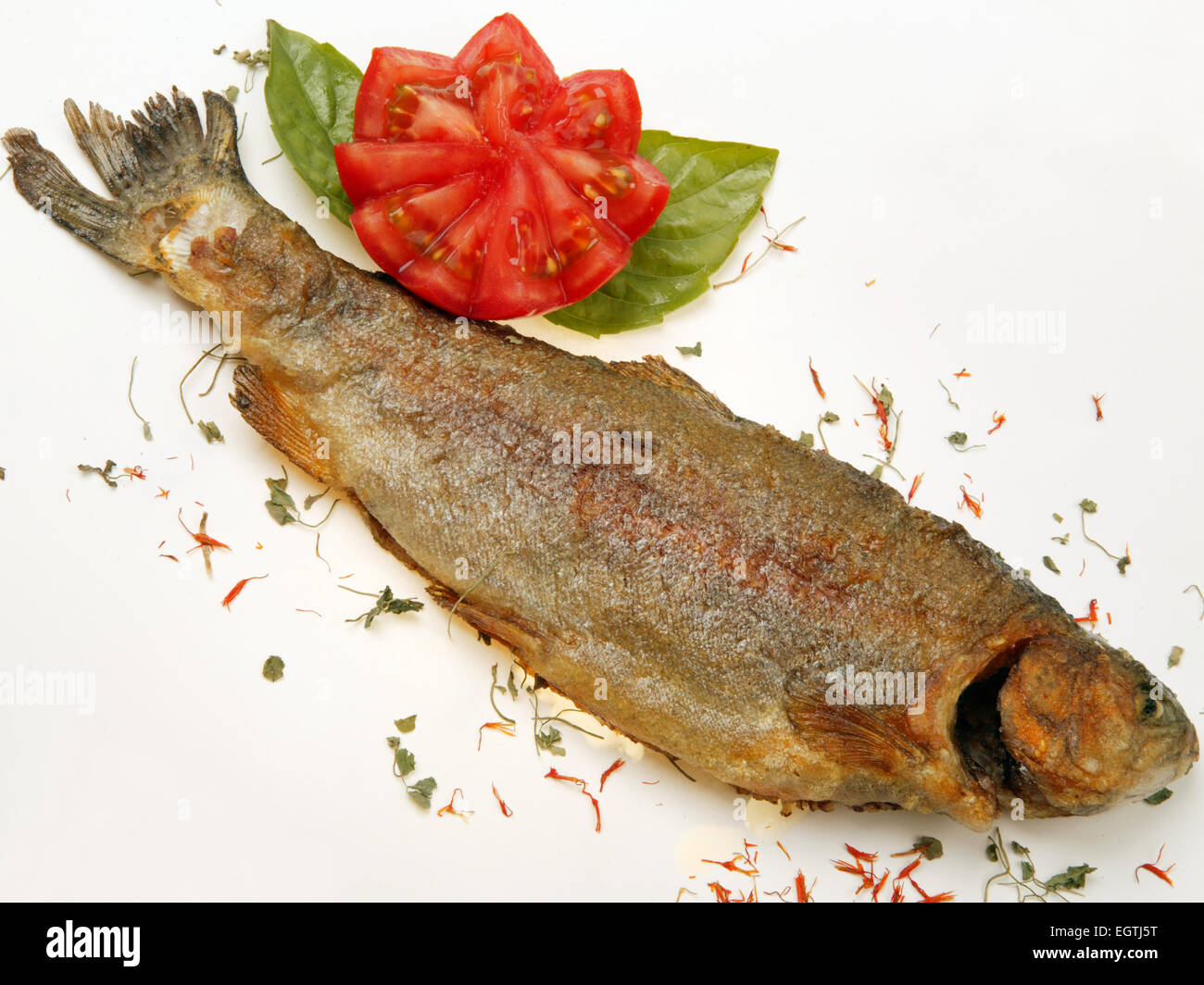 Fried fish with herbs and spices against white Stock Photo - Alamy